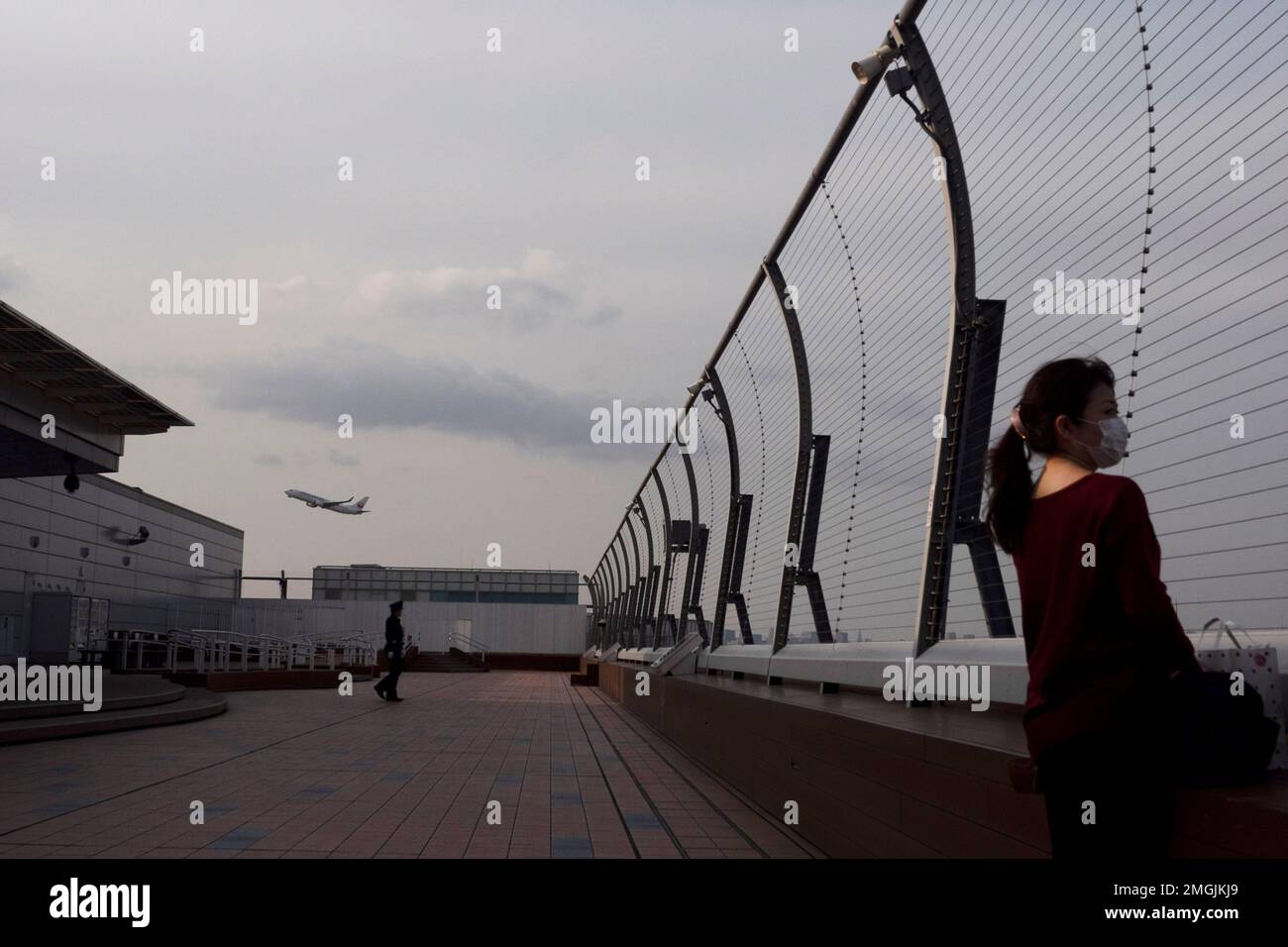 A woman visits an observation deck overlooking runways at the Haneda ...