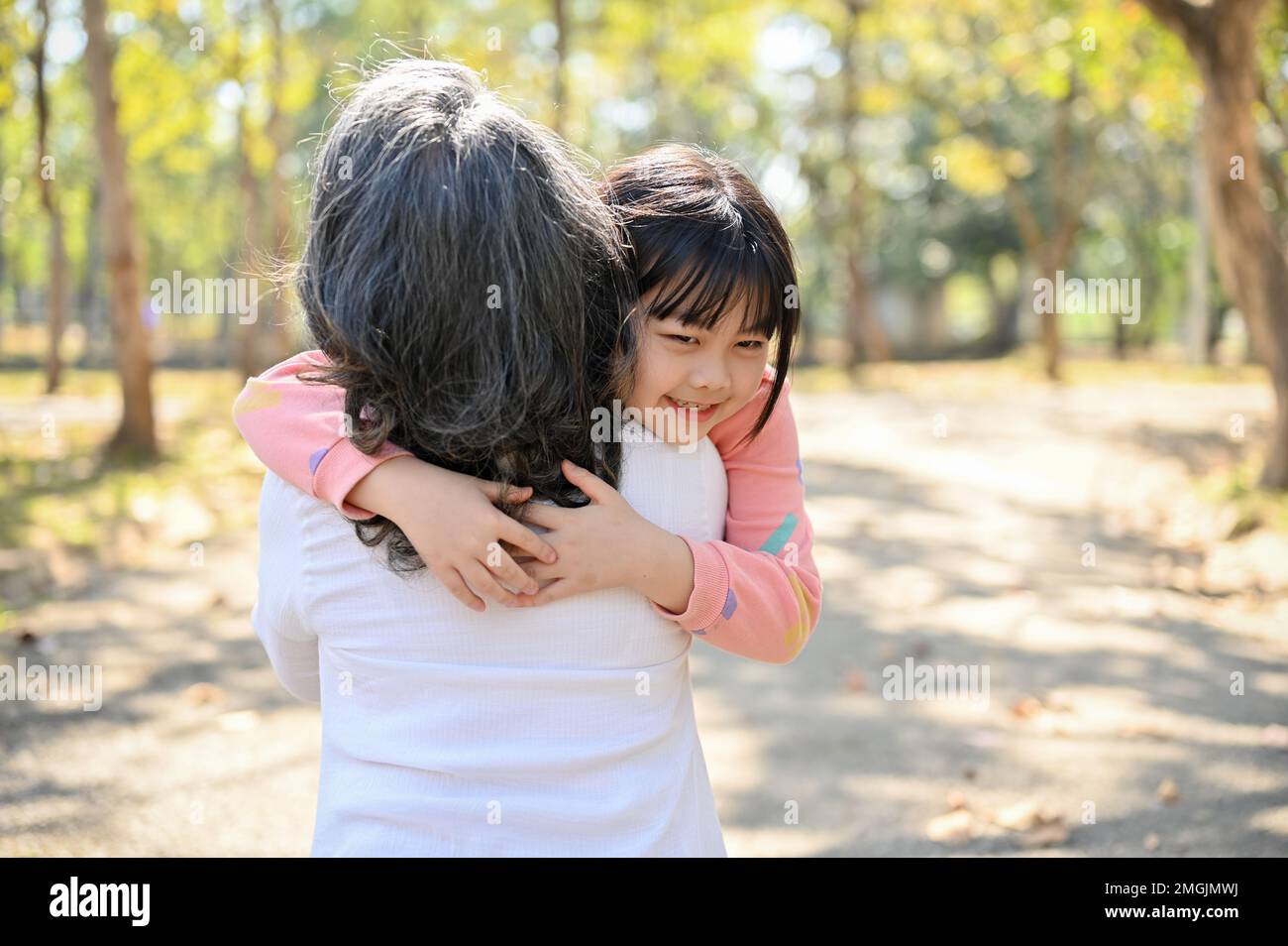 An adorable cute little Asian girl, granddaughter giving hug, cuddling ...