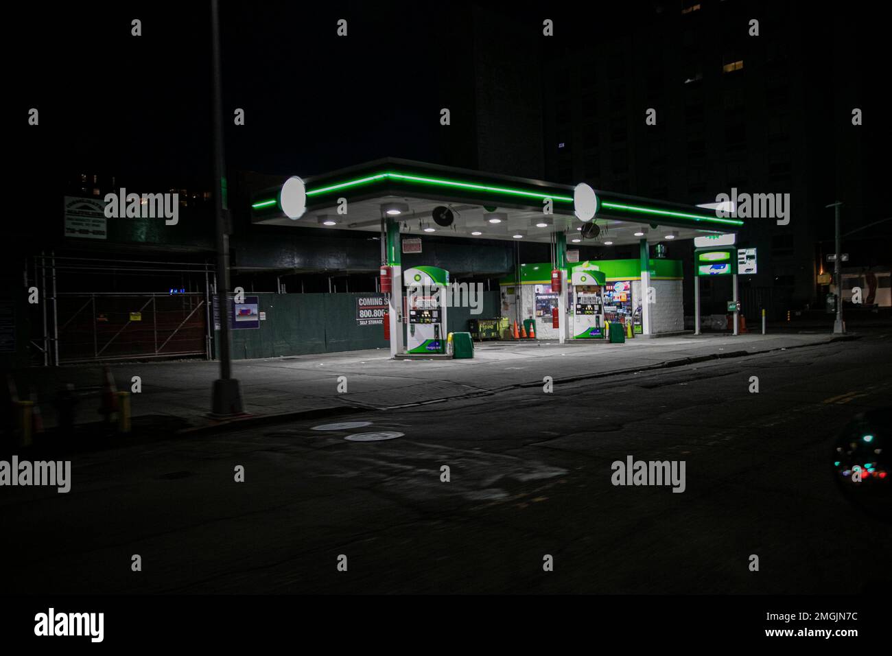 Lights illuminate a gas station on a dark and empty street in the ...