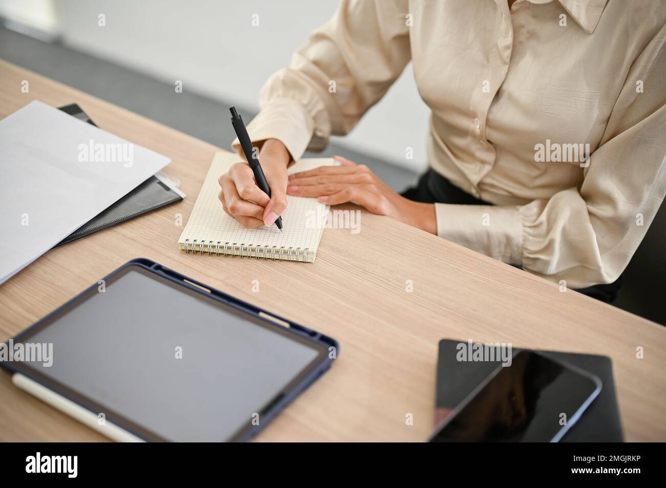 Top view of a professional Asian businesswoman taking notes or making ...