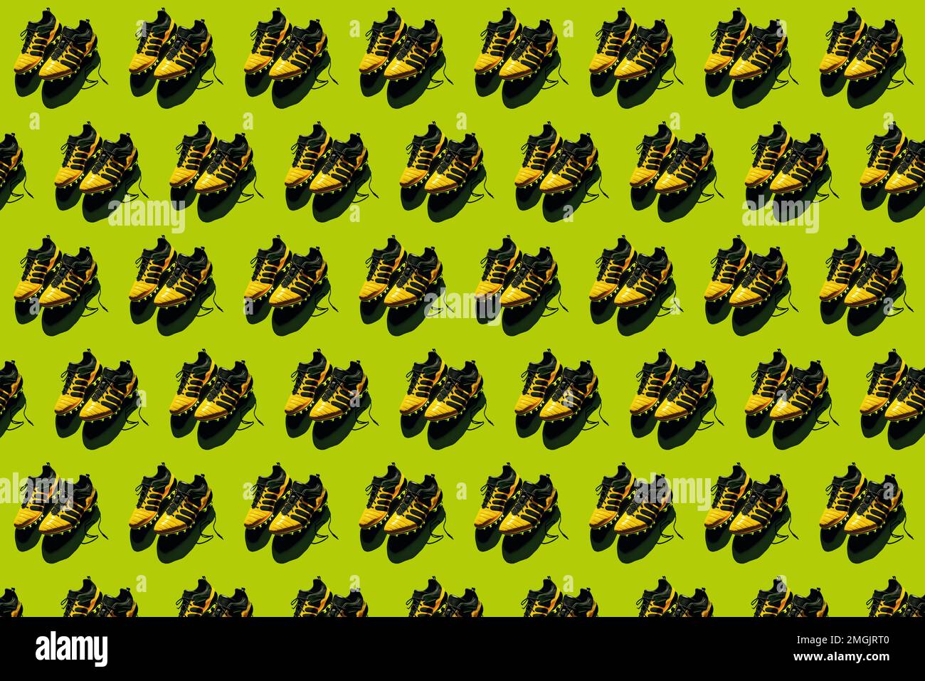 Pattern of orange and black football boots on a green background ...