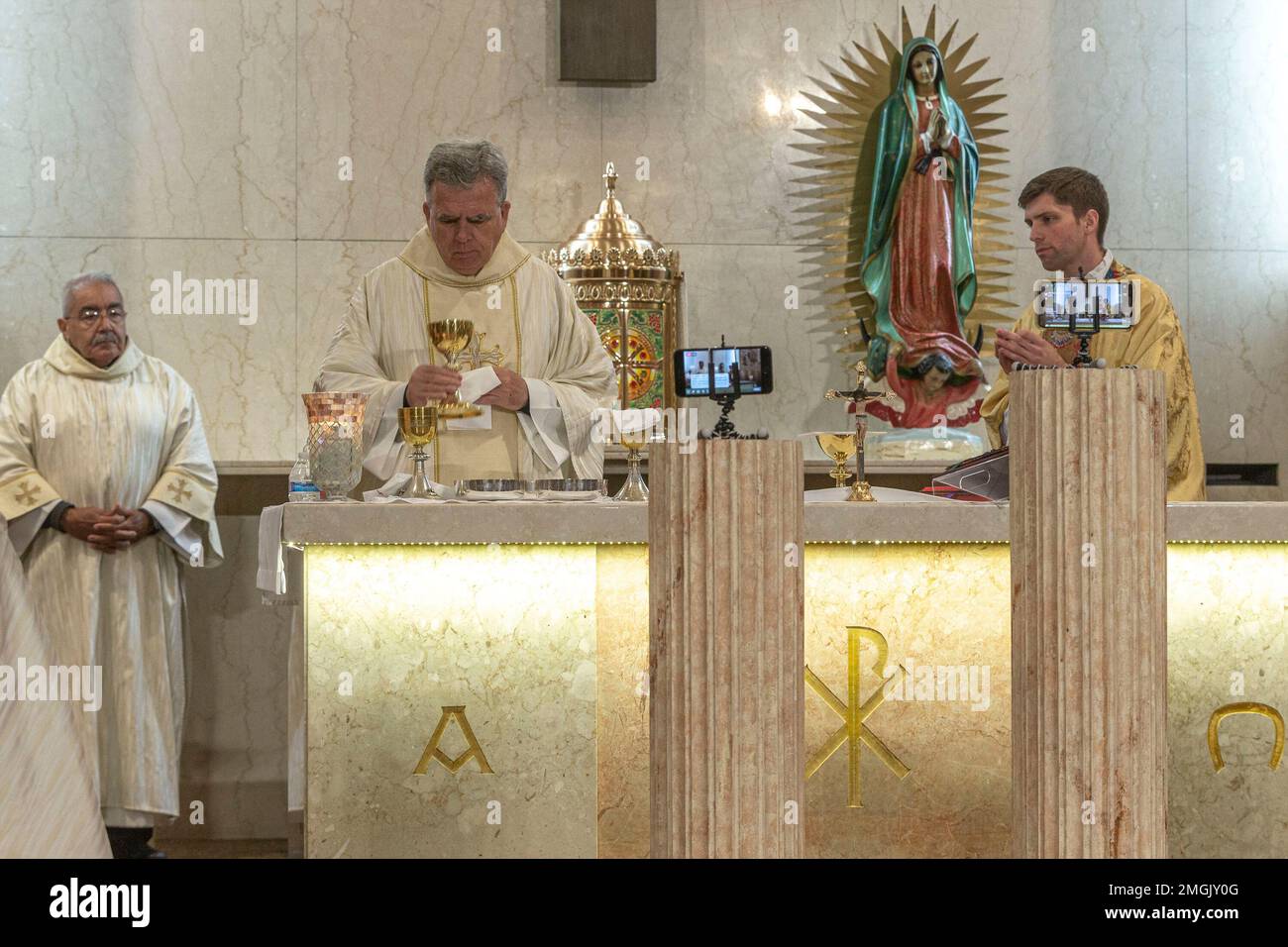 Deacon Manuel Chavez and Monsignor Austin Doran, second from left, join ...