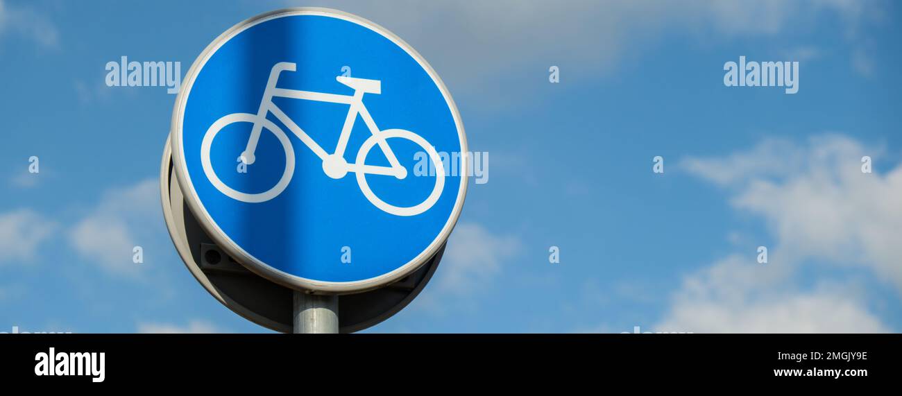 Round road sign depicting white bicycle on blue background, meaning mandatory bike path for ...