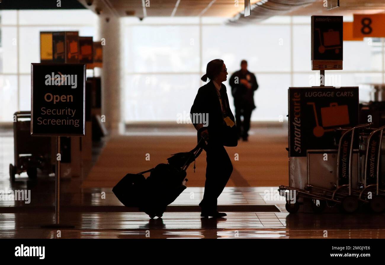 A lone traveller is silhouetted while heading to an escalator on the ...