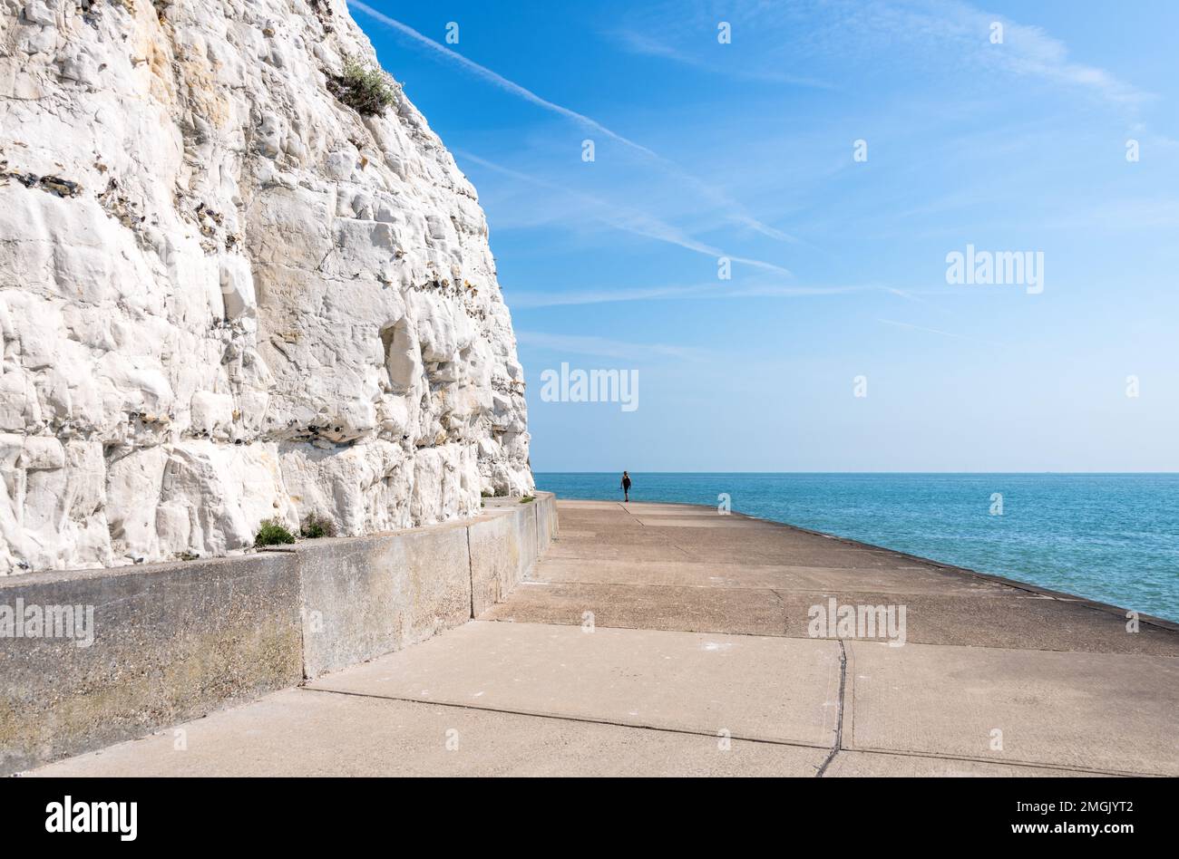 A woman walking along the cliffs on the Viking Coastal Trail from ...