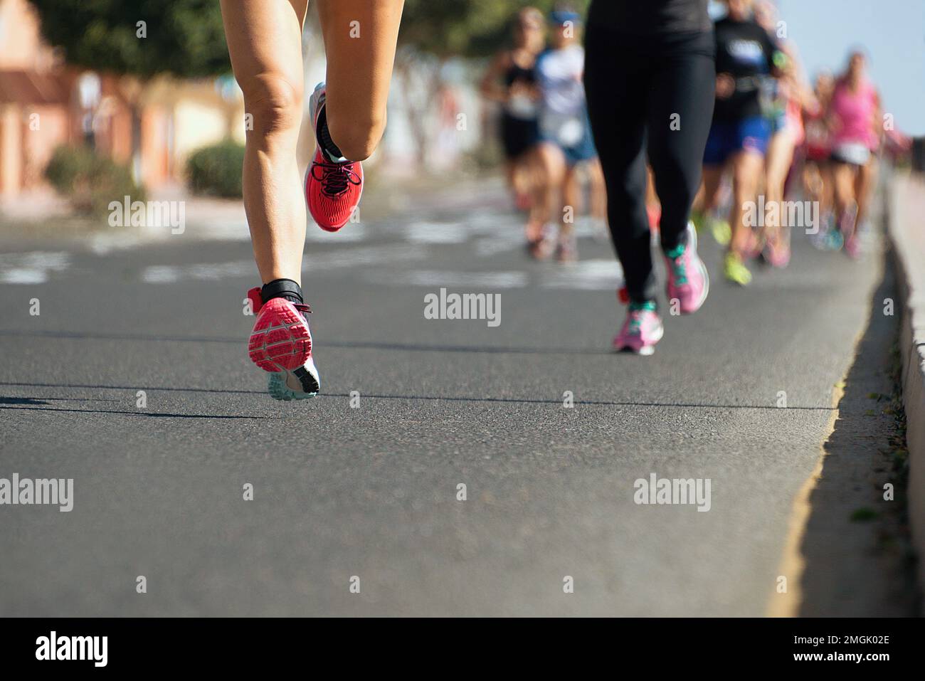 Marathon runners running on city road,detail on legs Stock Photo - Alamy