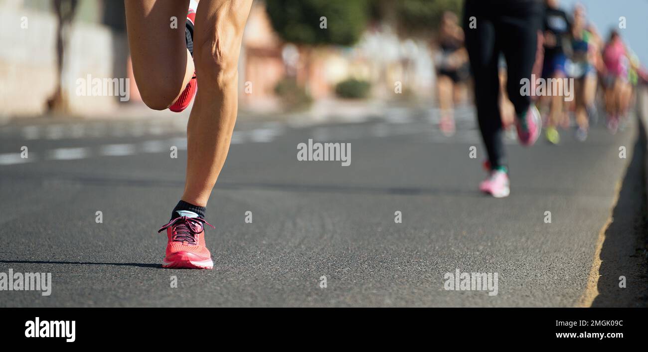 Marathon runners running on city road,detail on legs Stock Photo - Alamy