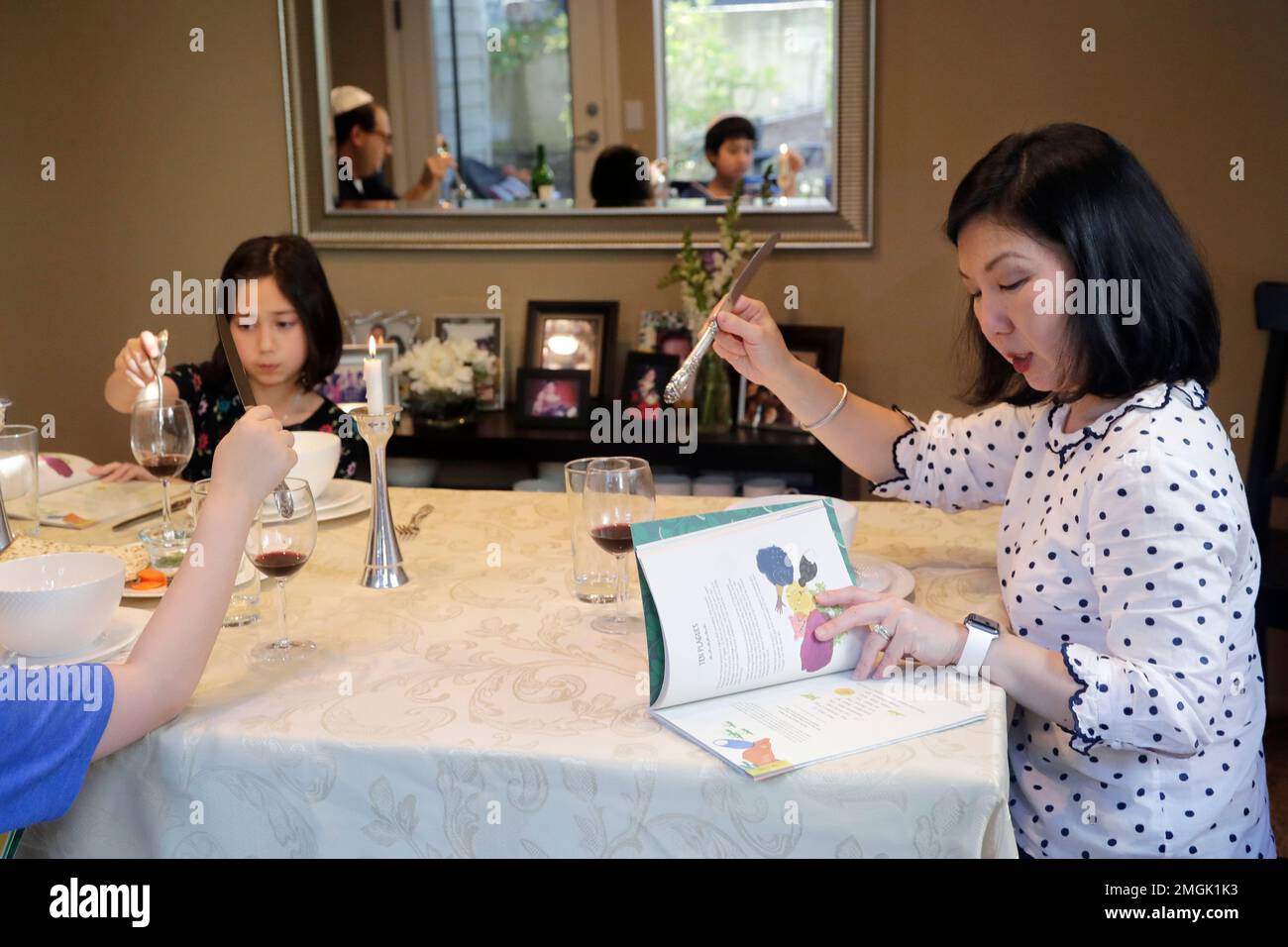 Jessica Choe, right, dips a knife into a glass of wine as she follows a ...