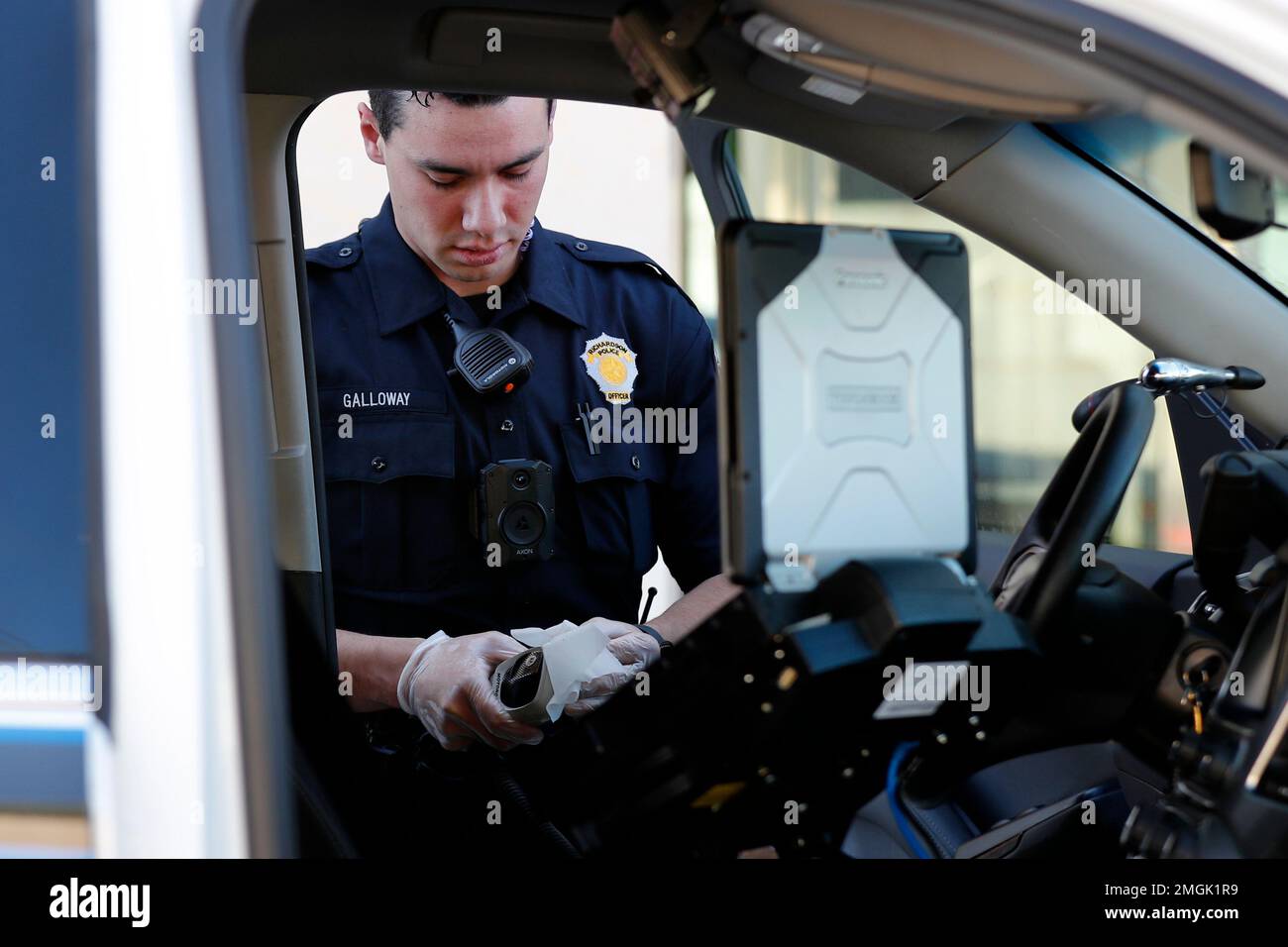 Richardson police officer Austin Galloway wears gloves and wipes down ...