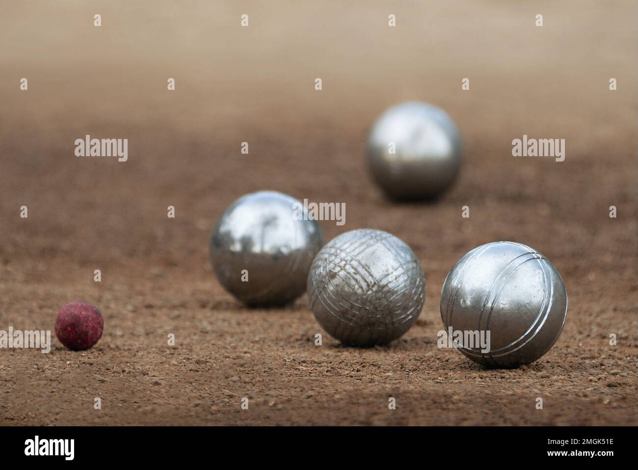 Metallic petanque four balls and a small wood jack Stock Photo - Alamy