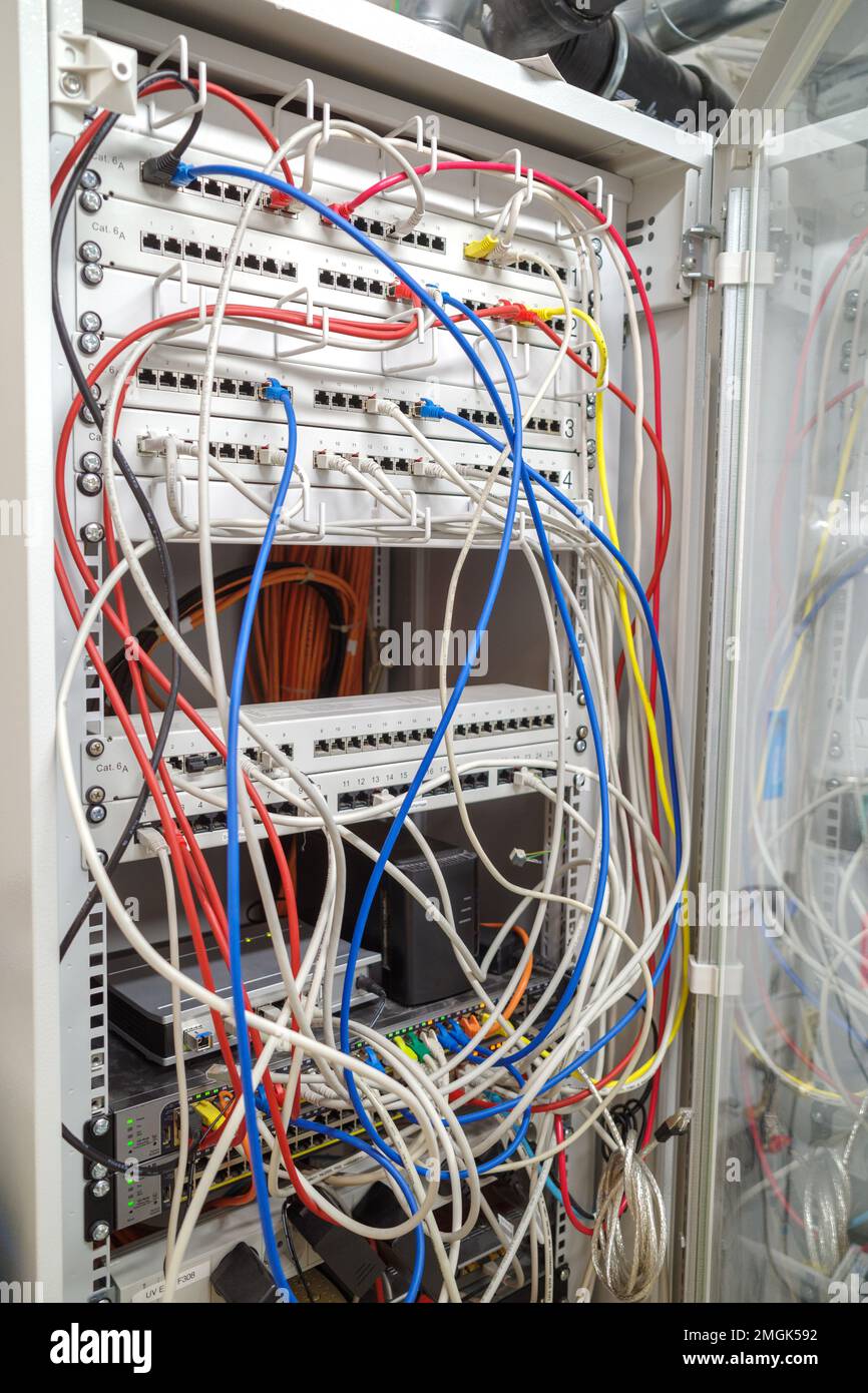 in the server rack many different colored network cables are connected ...