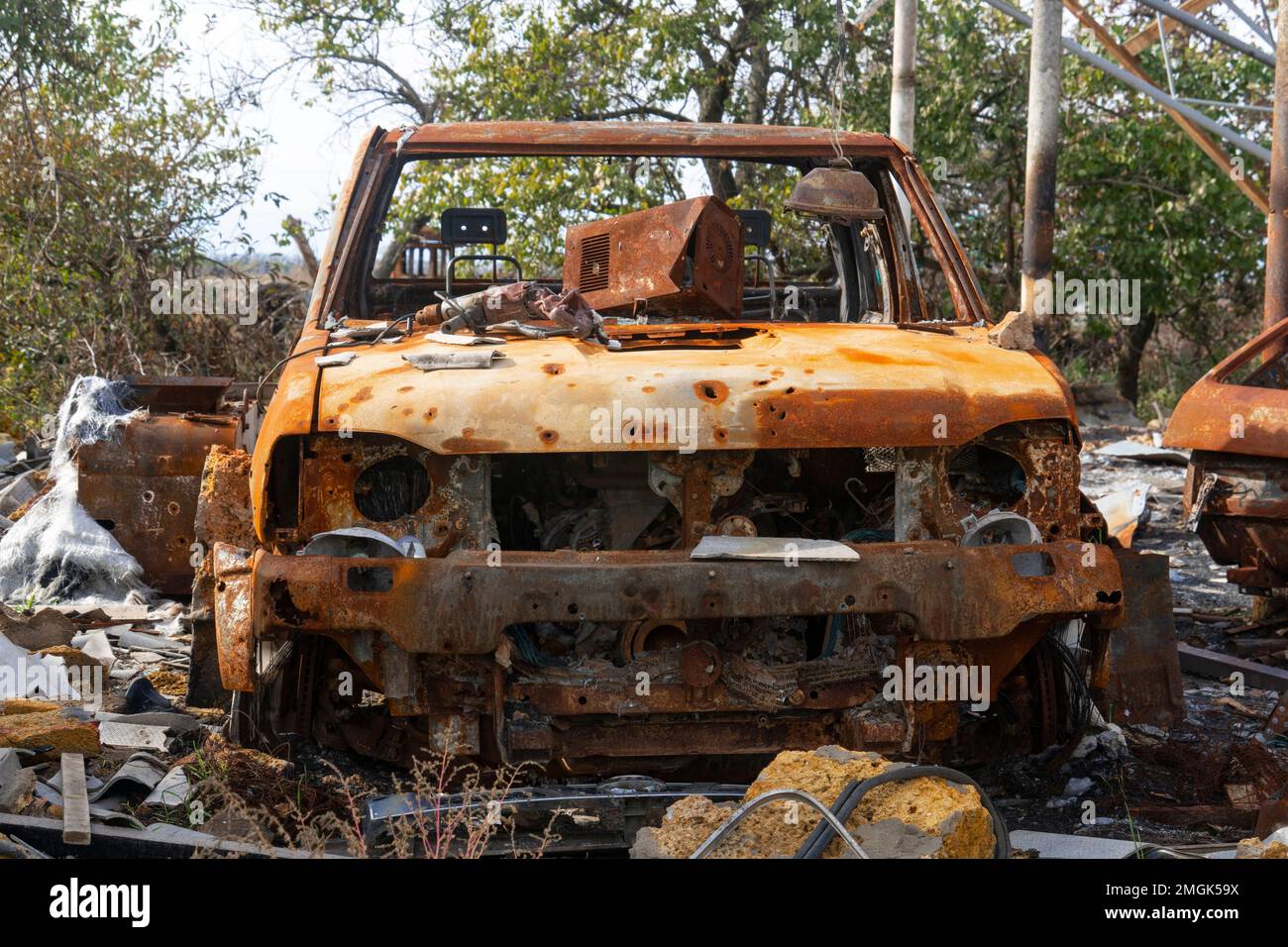 Countryside. Destroyed, burned-out civilian car stands in the yard of a ...