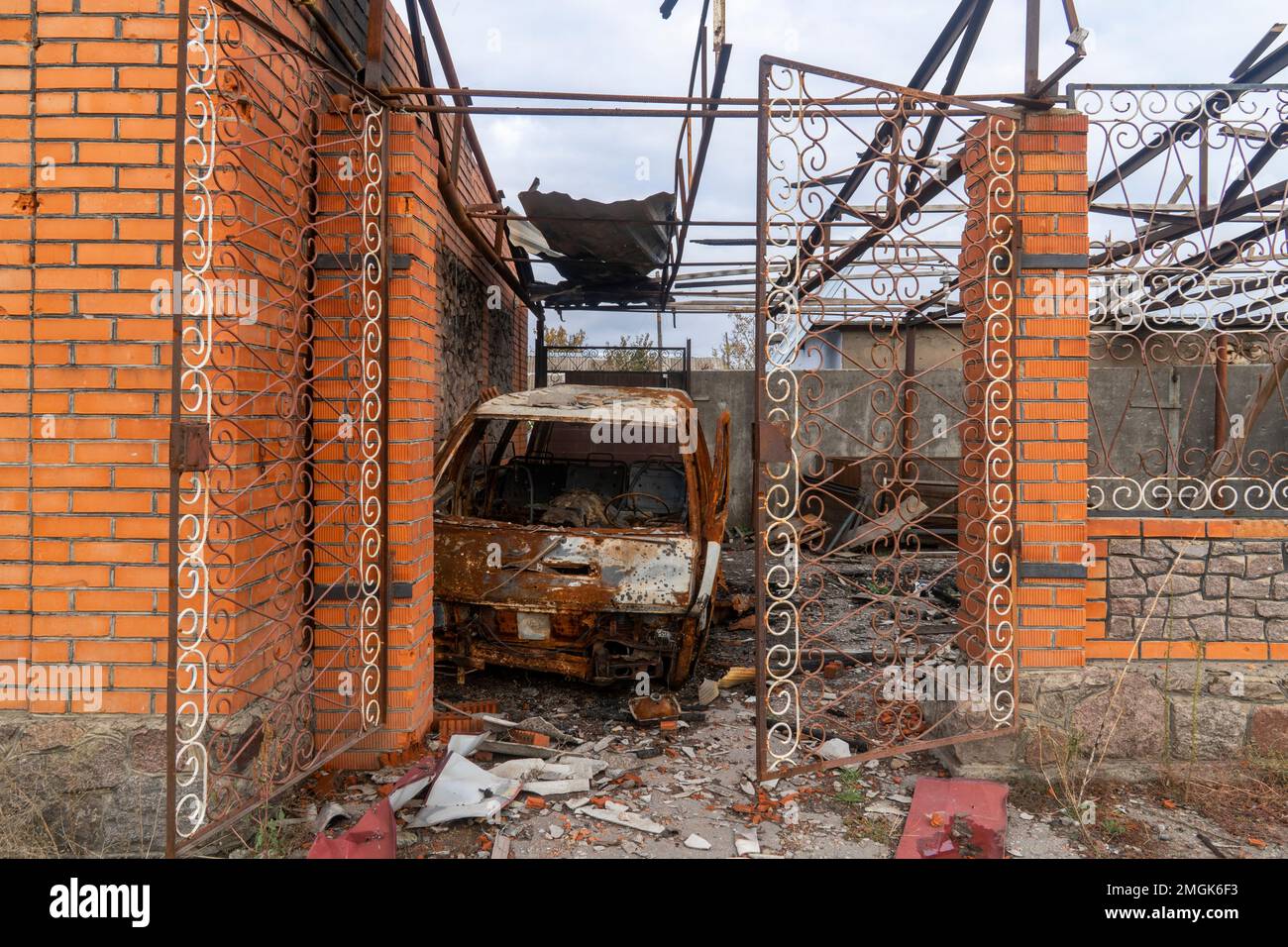Countryside. Destroyed, burned-out civilian car stands in the yard of a ...