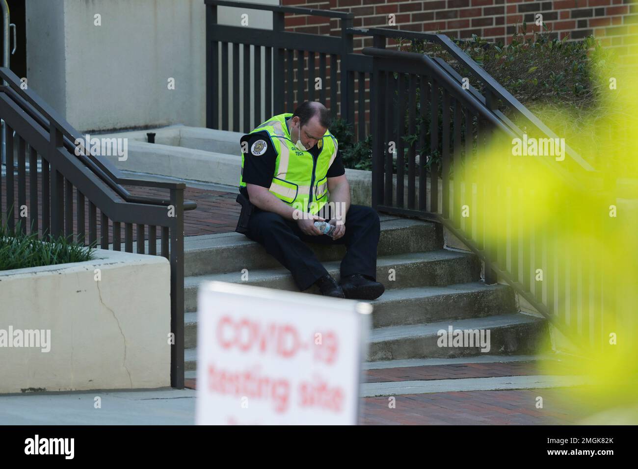 An official rests on a stoop near a COVID-19 testing site on Georgia ...