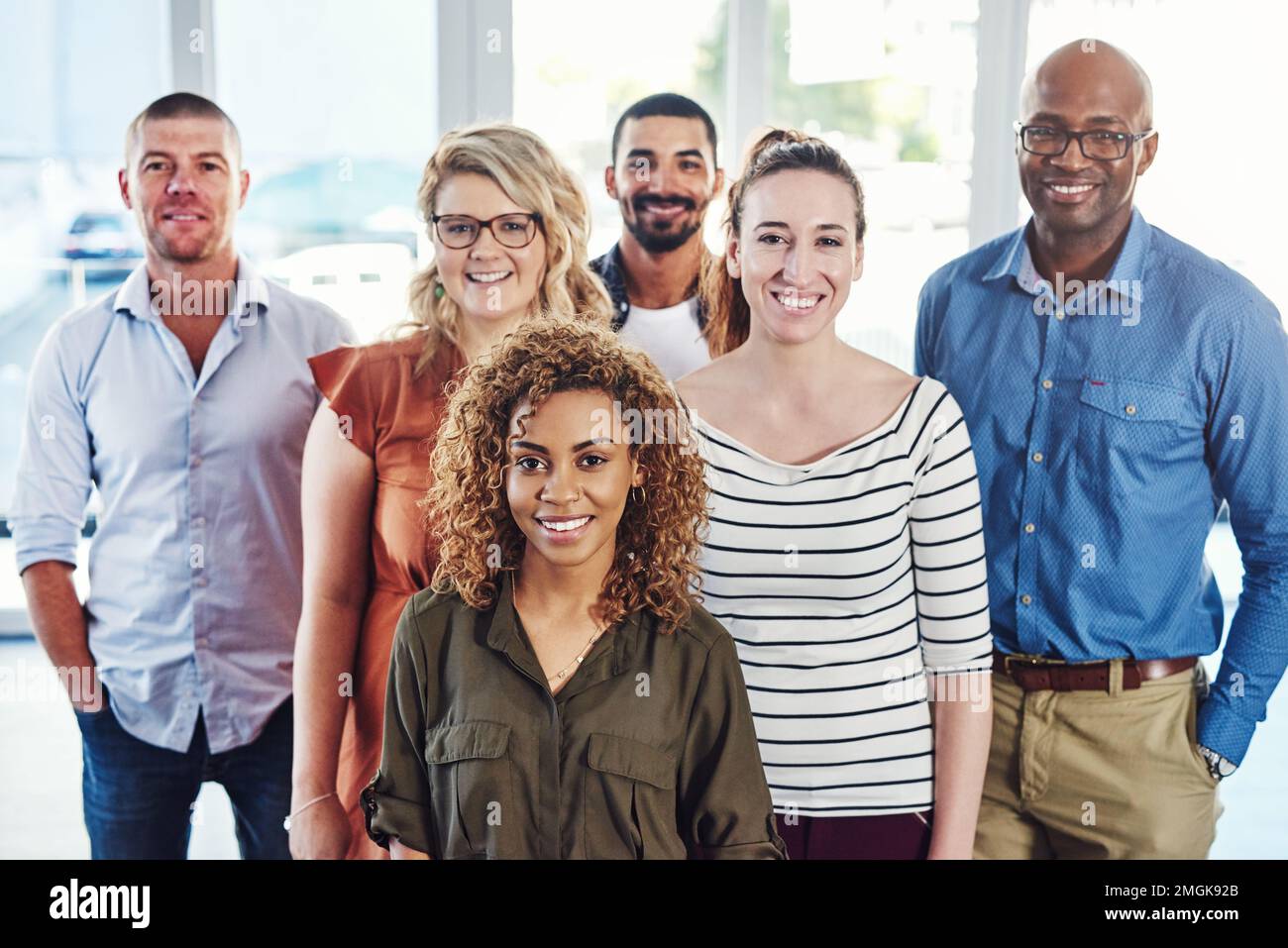 Cant help but feel optimistic. Portrait of a group of people standing ...