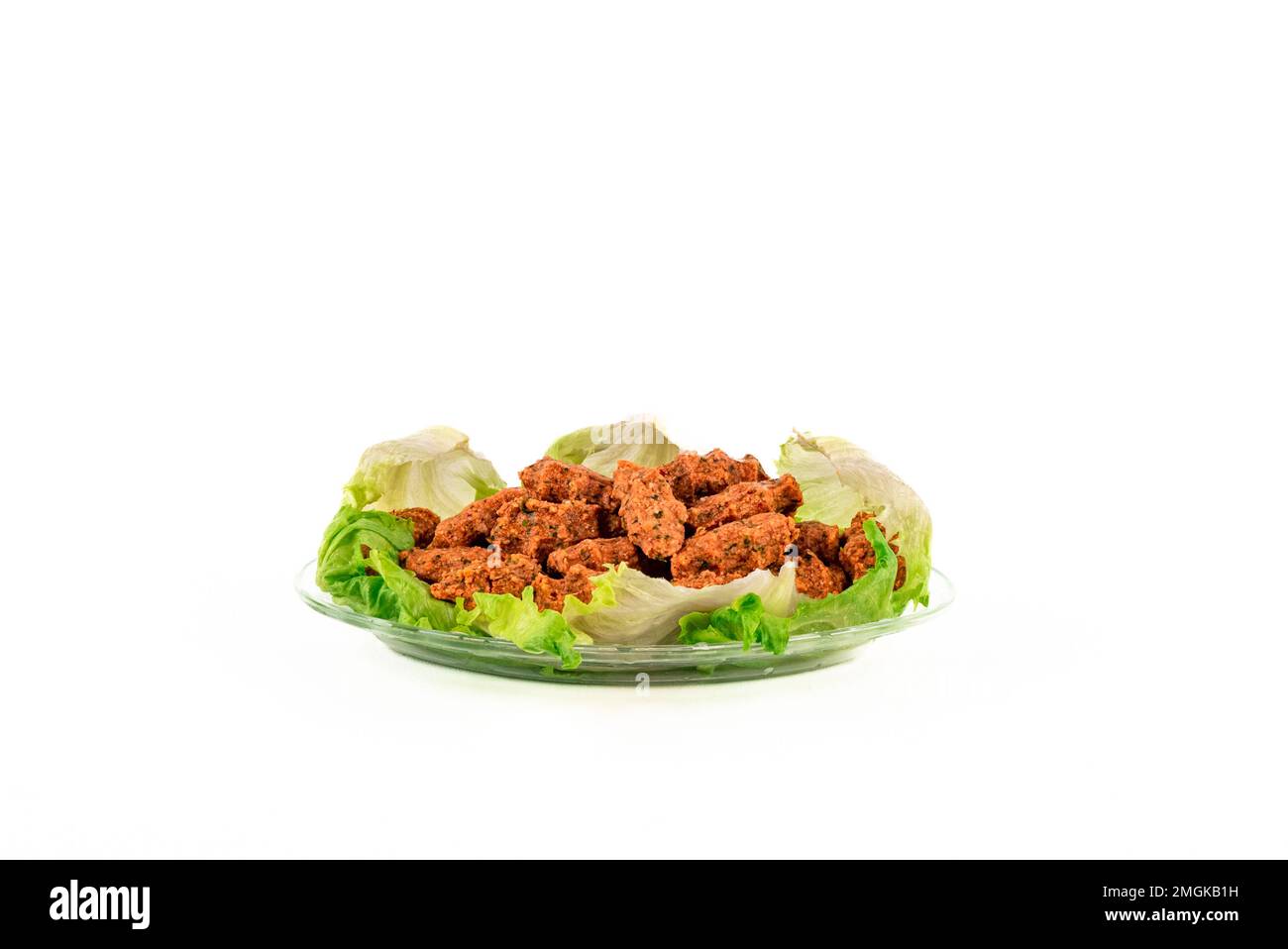 Turkish vegan lentil balls with lettuce isolated on glass plate ...