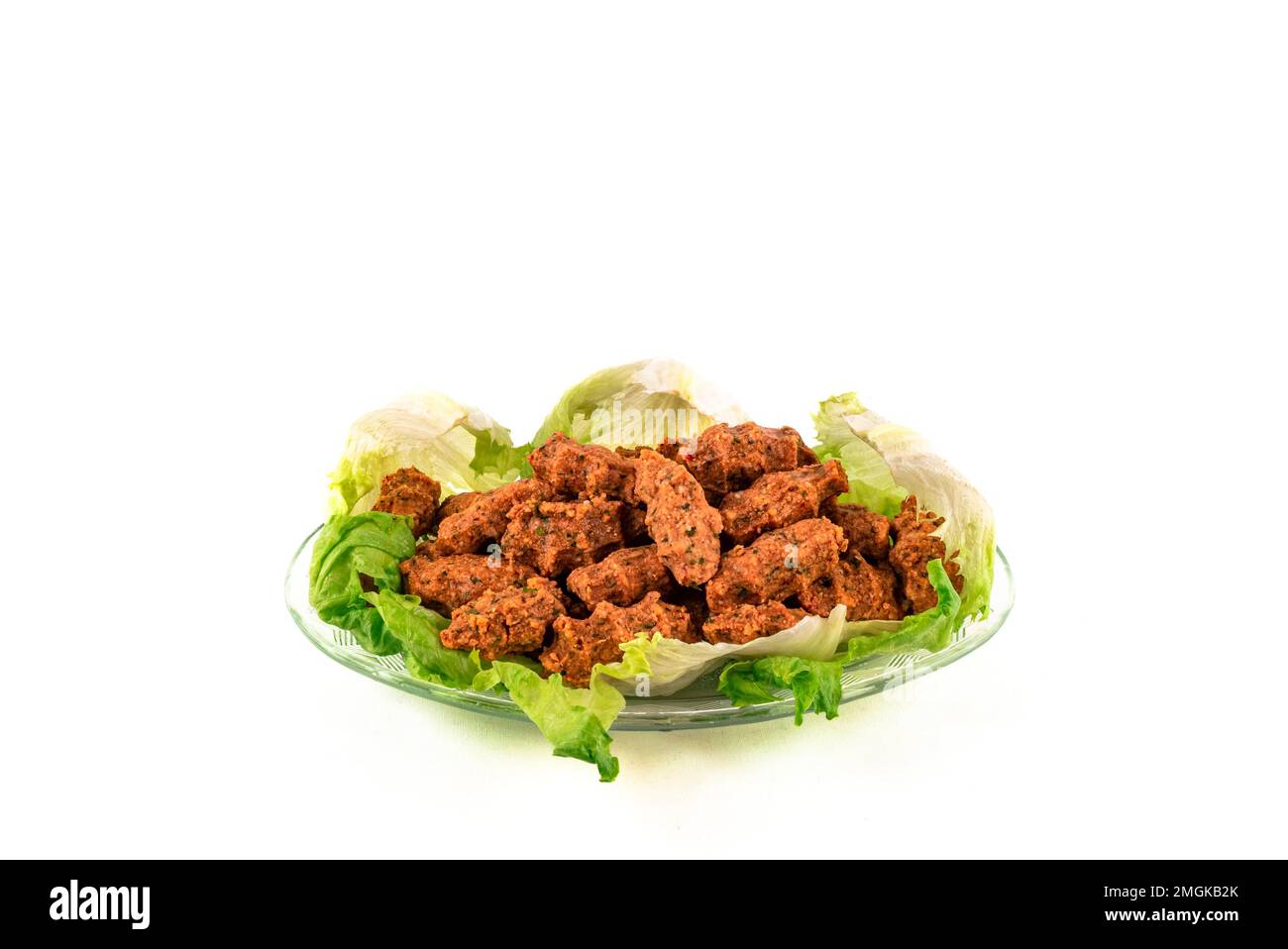 Close up Turkish vegan lentil balls with lettuce isolated on glass ...