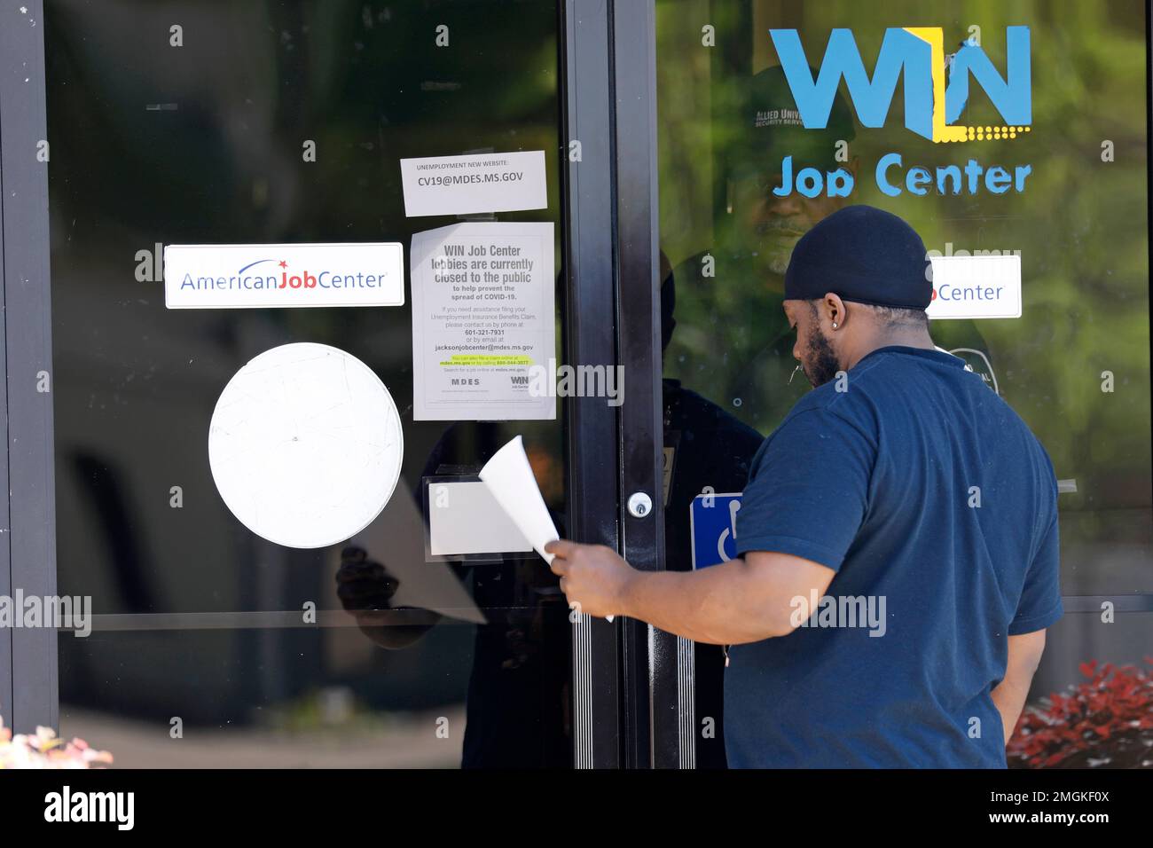 Tyrone Keoton Jr., is handed an unemployment benefit application form ...