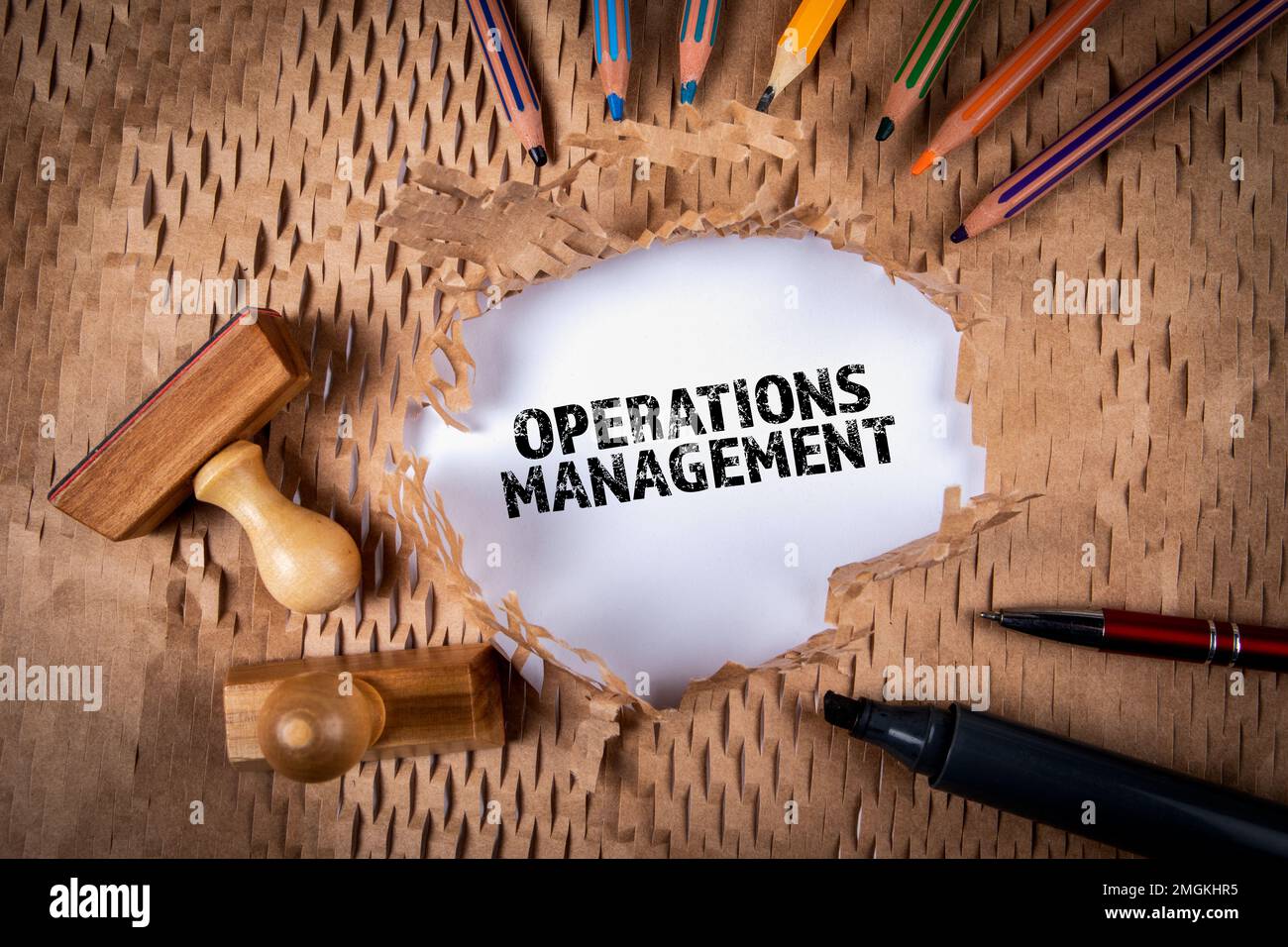 Operations Management. Office supplies on a torn cardboard background ...