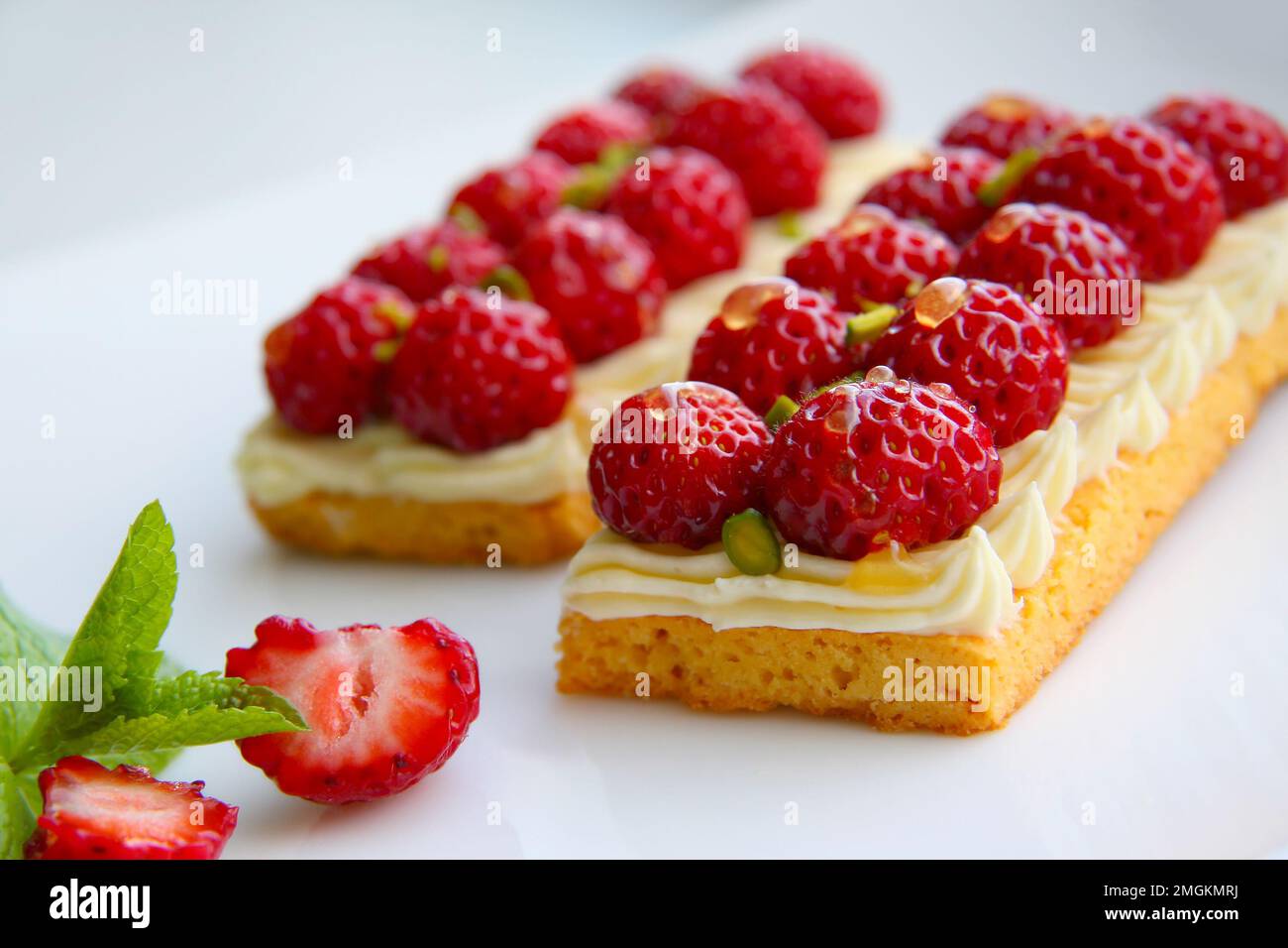 two fresh strawberry tarts with cream, pistachio and honey Stock Photo ...