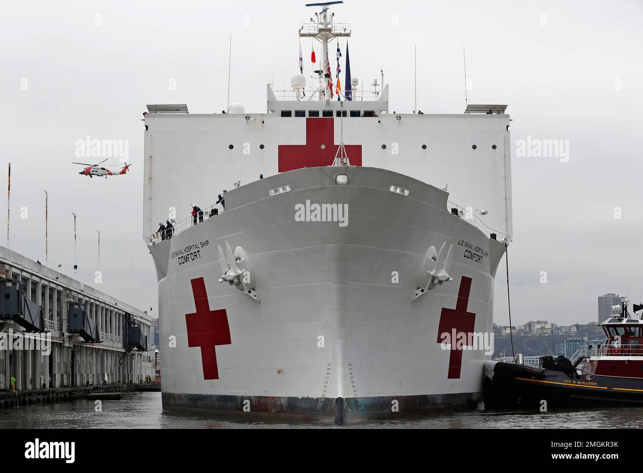 A U.S. Coast Guard helicopter flies overhead as the USNS Comfort, a ...