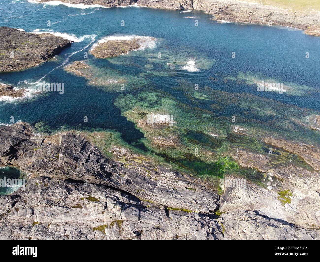 An aerial view of a group of small rocky islands in the clear blue sea ...