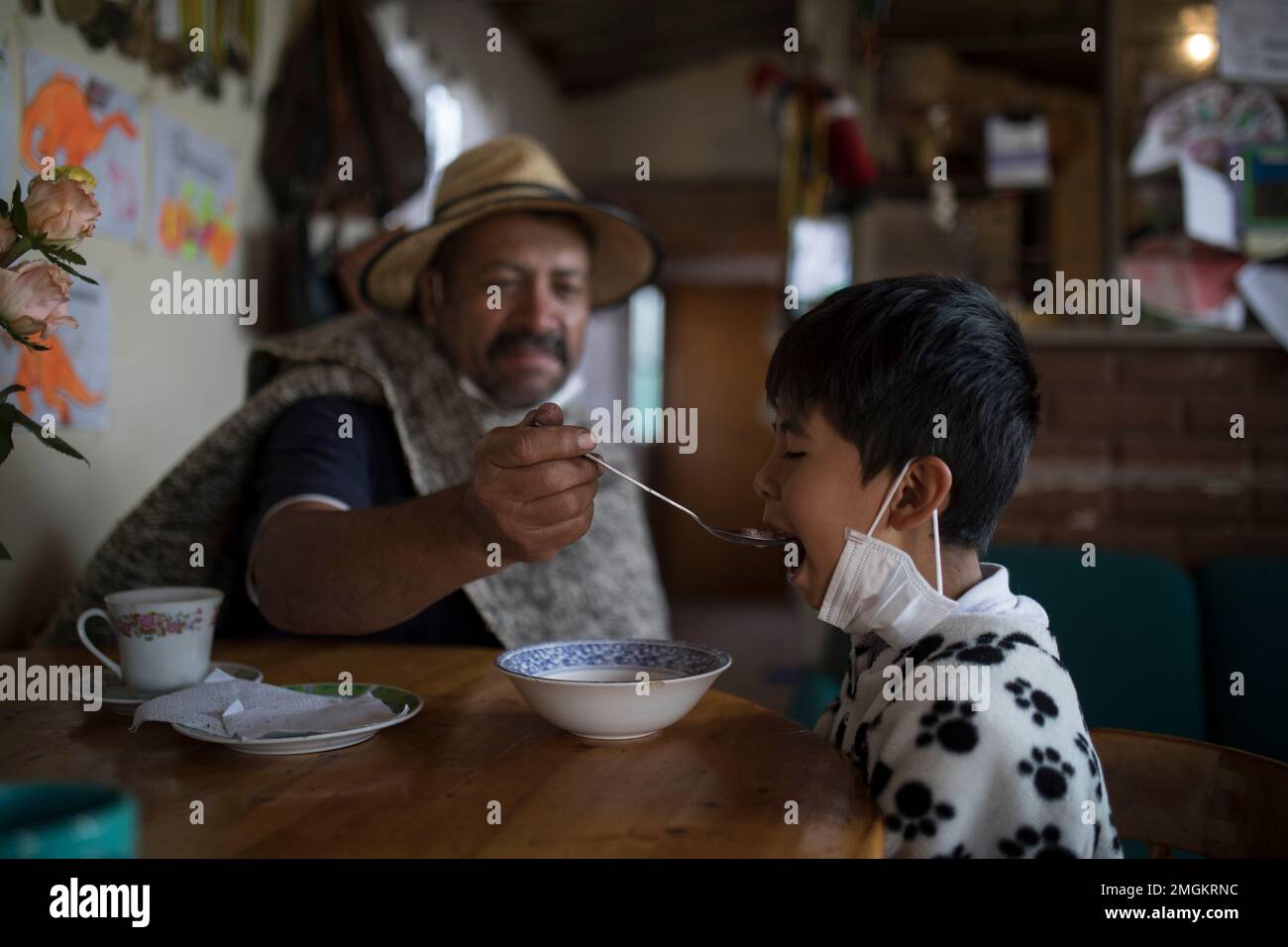 Jaime Ramirez feeds his son Gabriel in Chia, Colombia, March 23, 2020 ...