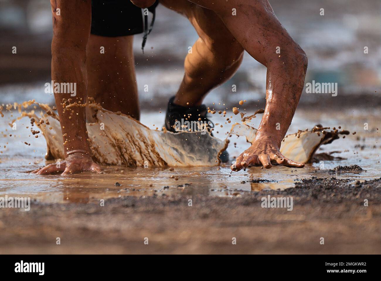 Mud race runners.Crawling,passing under a barbed wire obstacles during ...