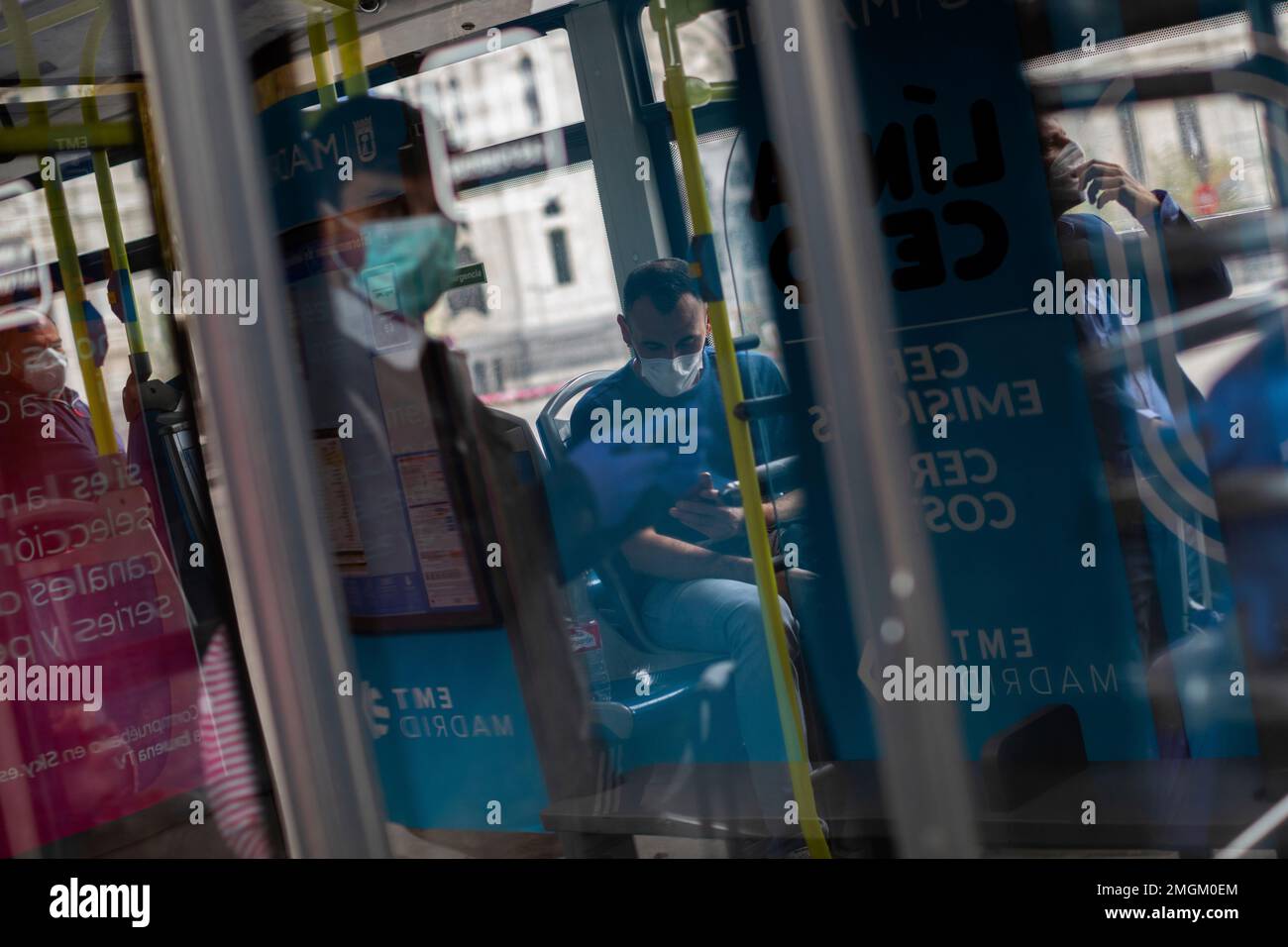 Commuters wear face masks inside a bus in Madrid, Spain, March 22, 2020 ...