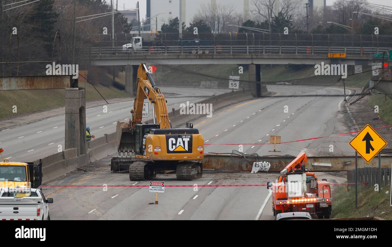 Workers clean debris from a collapsed pedestrian bridge on westbound ...