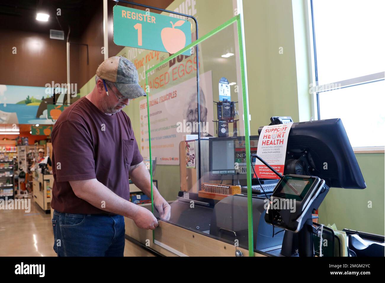 Martin Ragain, of Wichita, Kan., installs a plexiglass shield on a ...