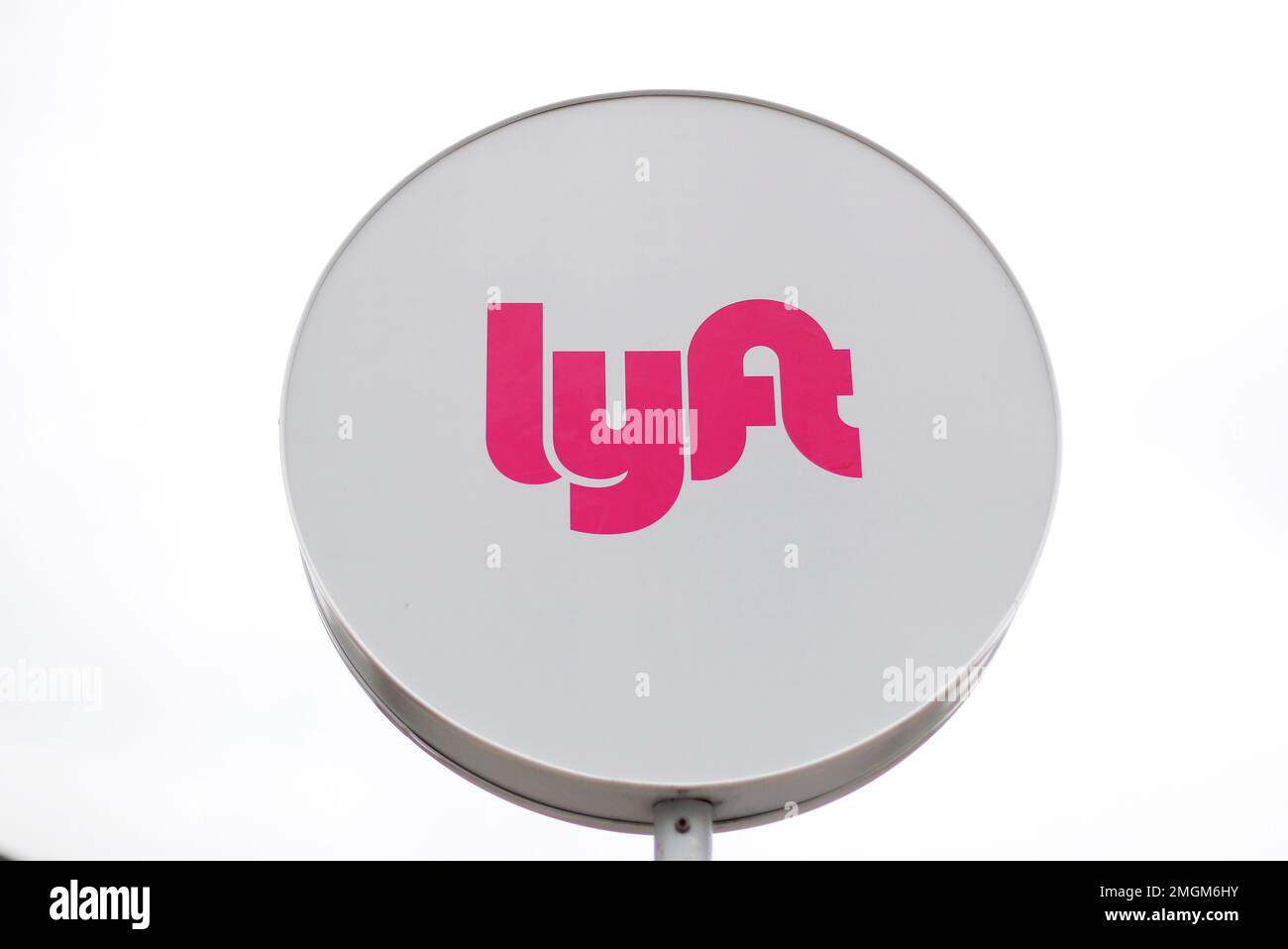 A Lyft sign is shown at a shared ride pickup location for automobiles ...