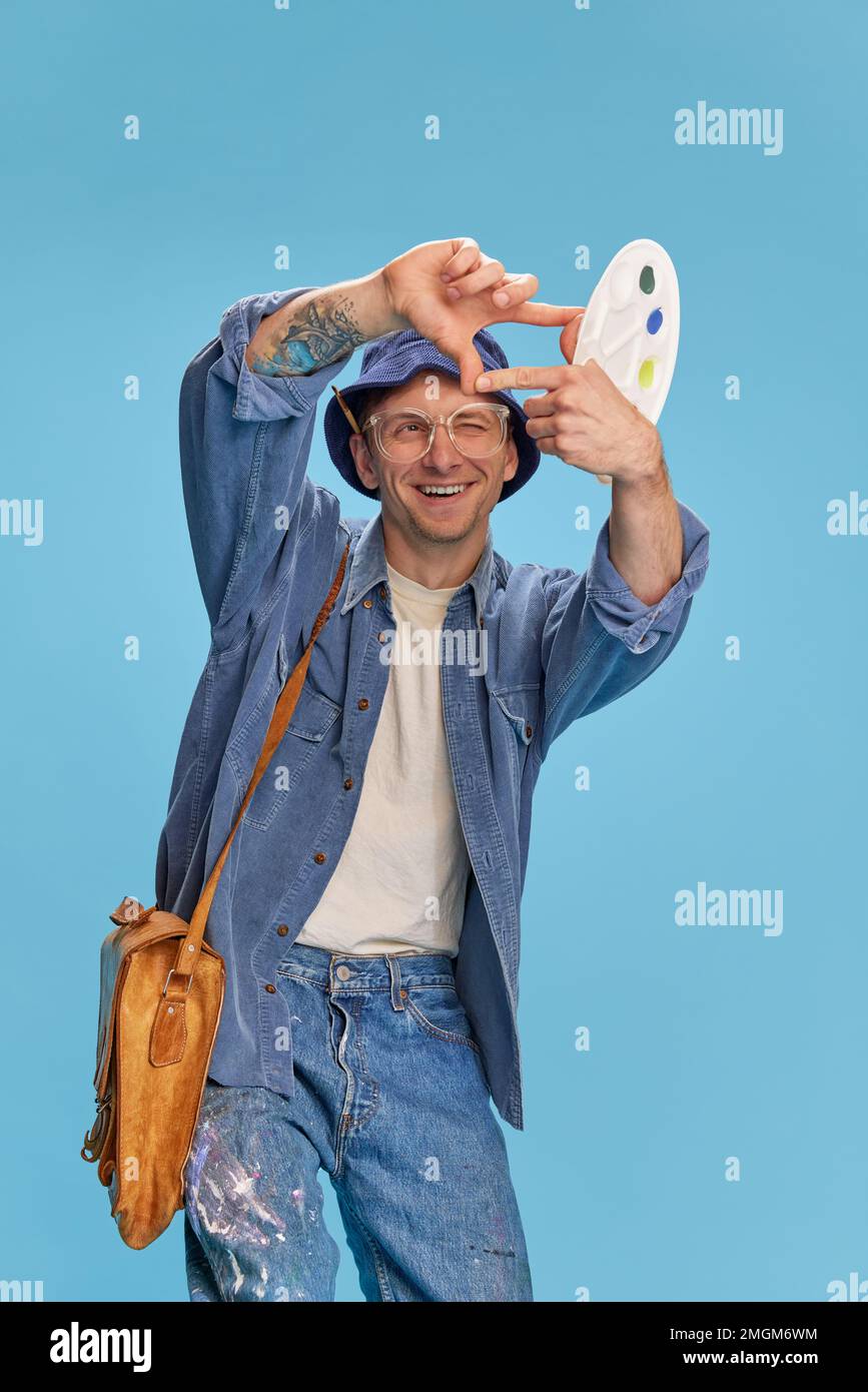 Choosing frame to draw. Portrait of young man in jeans clothes, painter ...