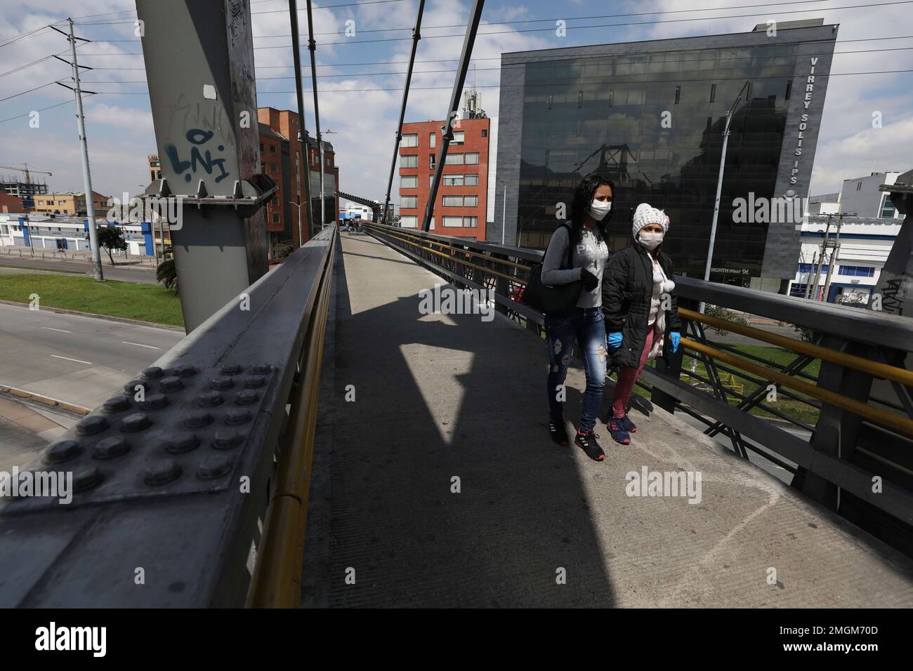 People walk on an empty pedestrian bridge in Bogota, Colombia ...