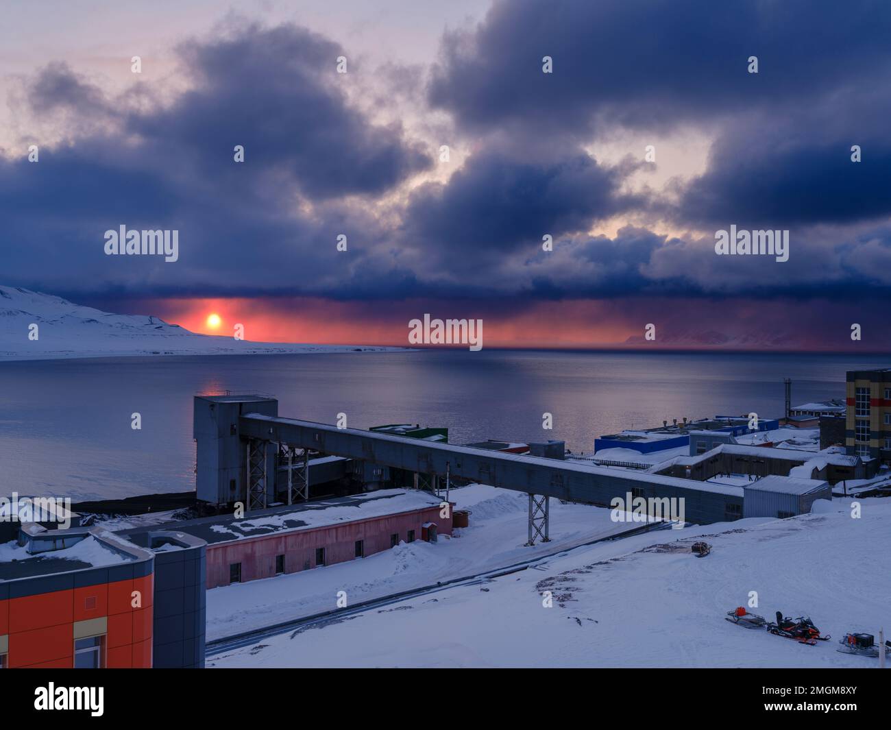 Sunset over the mine. Russian coal mining town Barentsburg at fjord ...