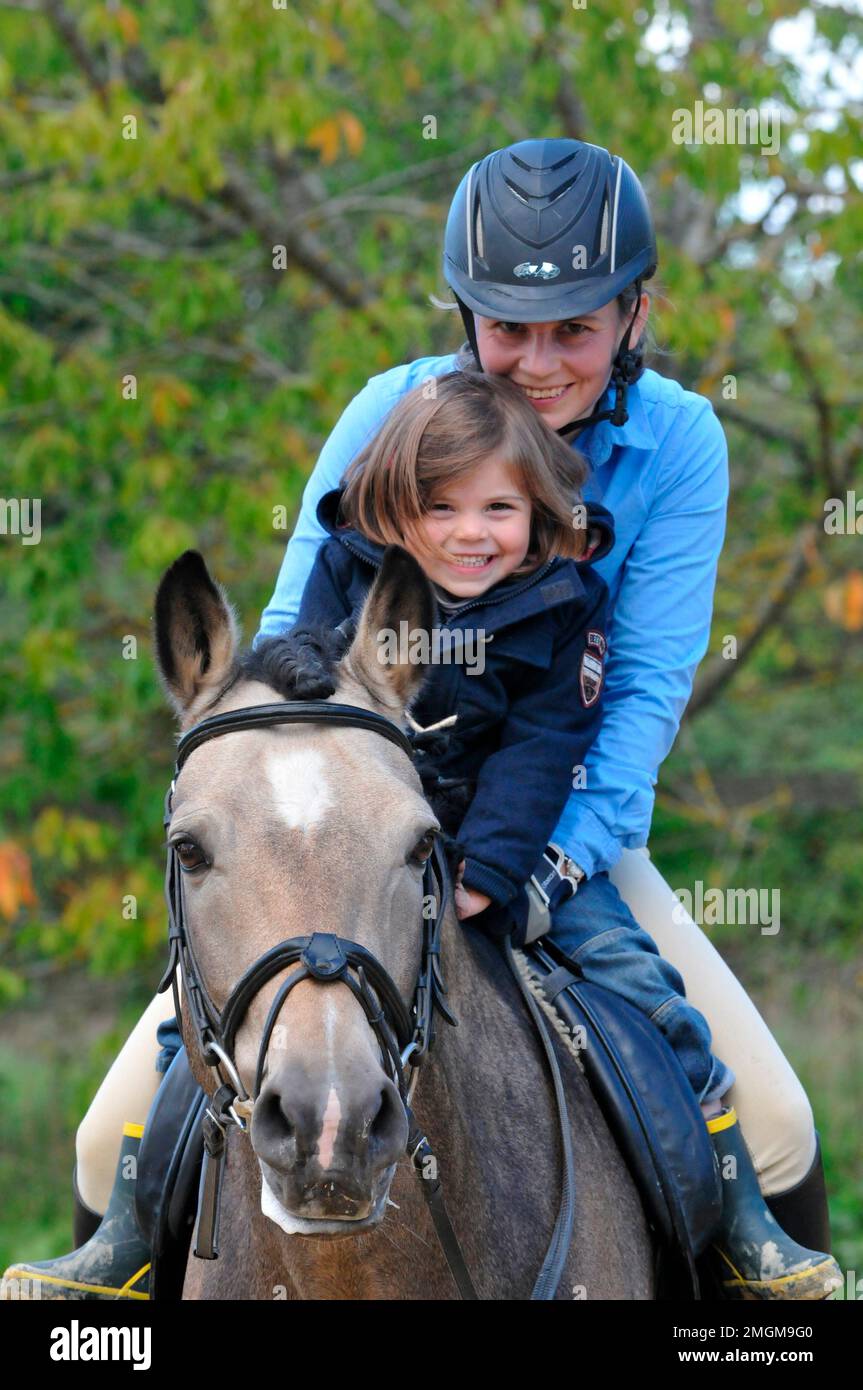 Woman rider with a little girl on a New Forest stallion - family and ...