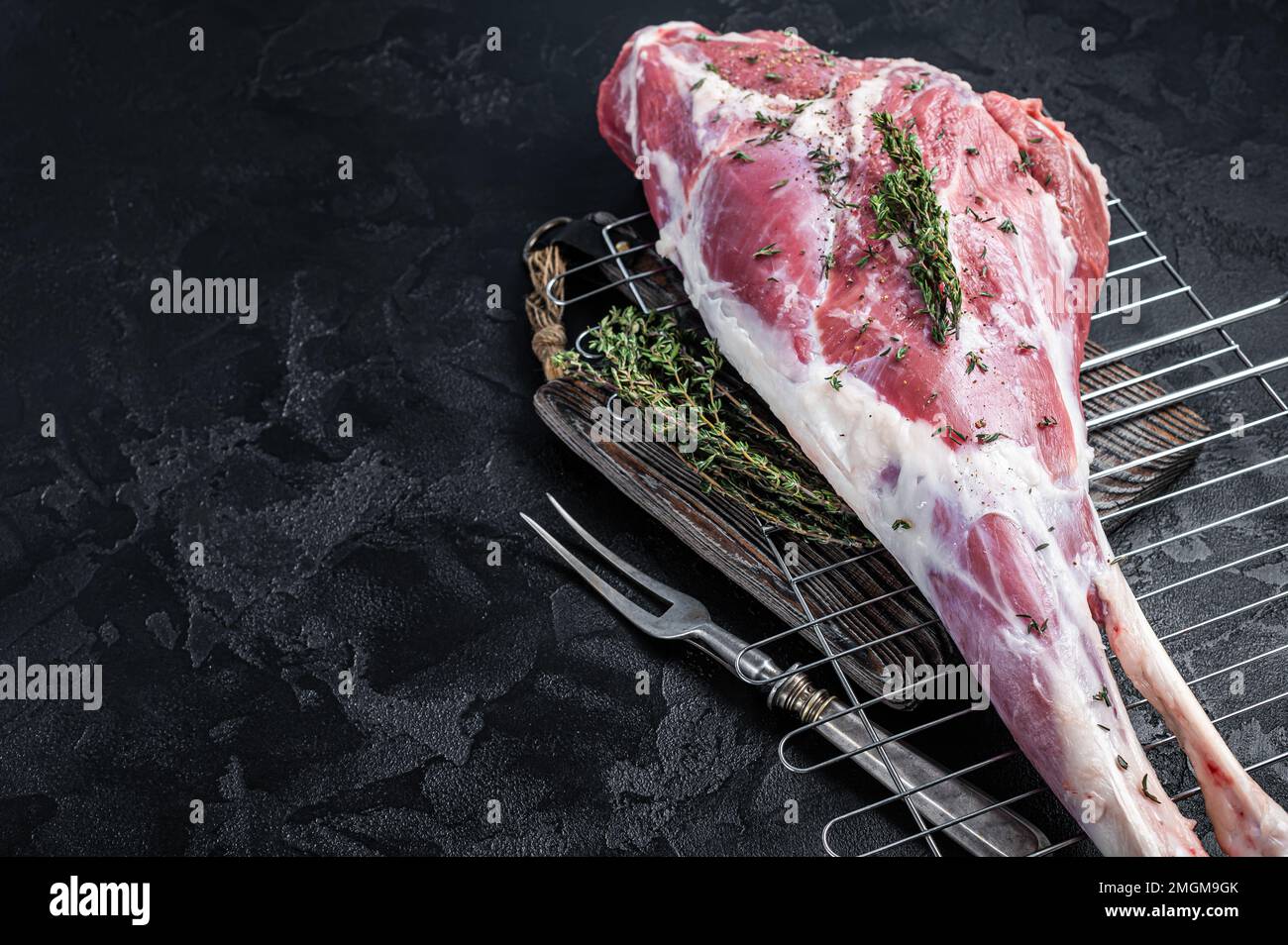 Marinated raw lamb mutton Leg Thigh with thyme and spices. Black ...
