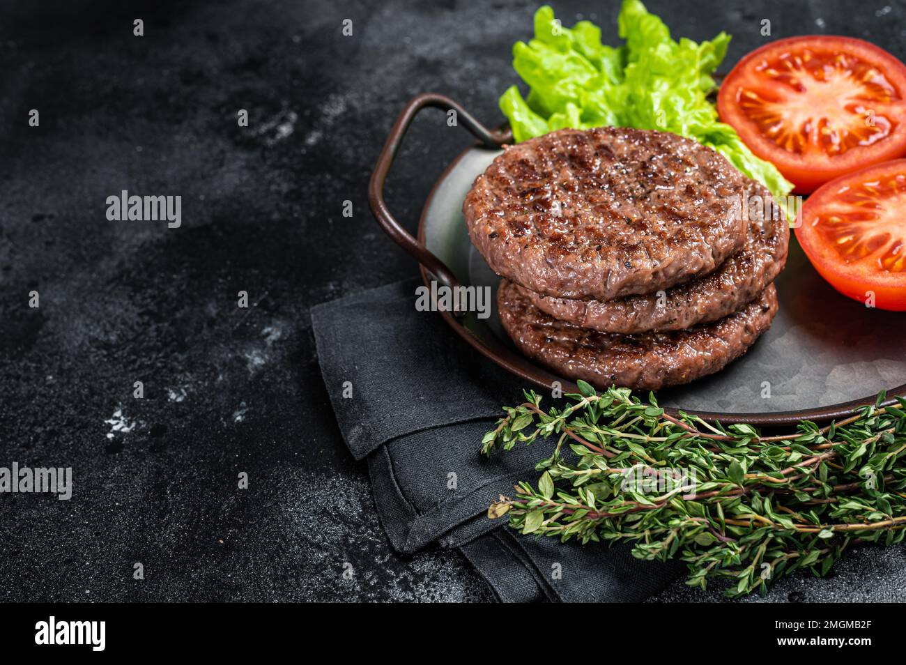 Tasty grilled burger beef patty with tomato, spices and lettuce in ...