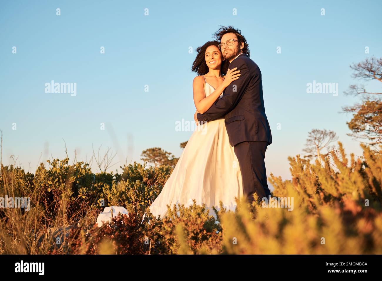Bride, groom and wedding in nature at sunset by interracial couple ...