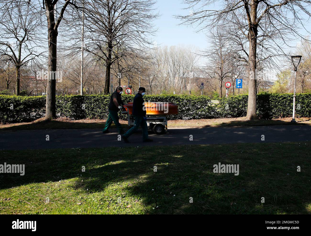 Two men carry a coffin to the Melegnano cemetery's morgue, outskirts of ...