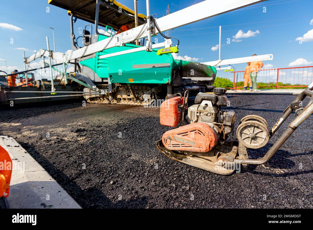 View on worker who is compacting asphalt with vibration plate ...