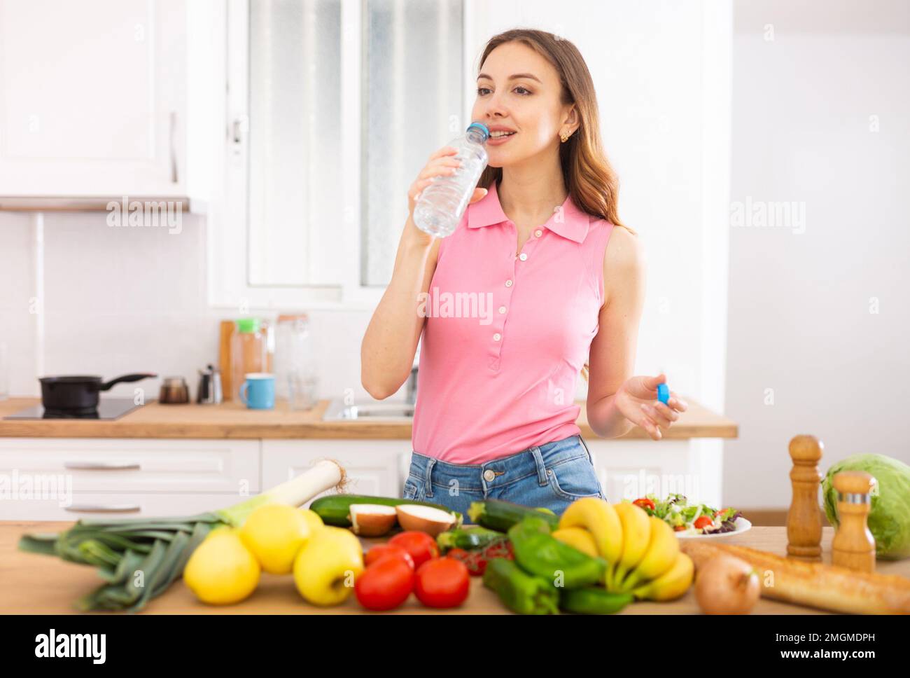 Young attractive woman drinking water at home Stock Photo - Alamy