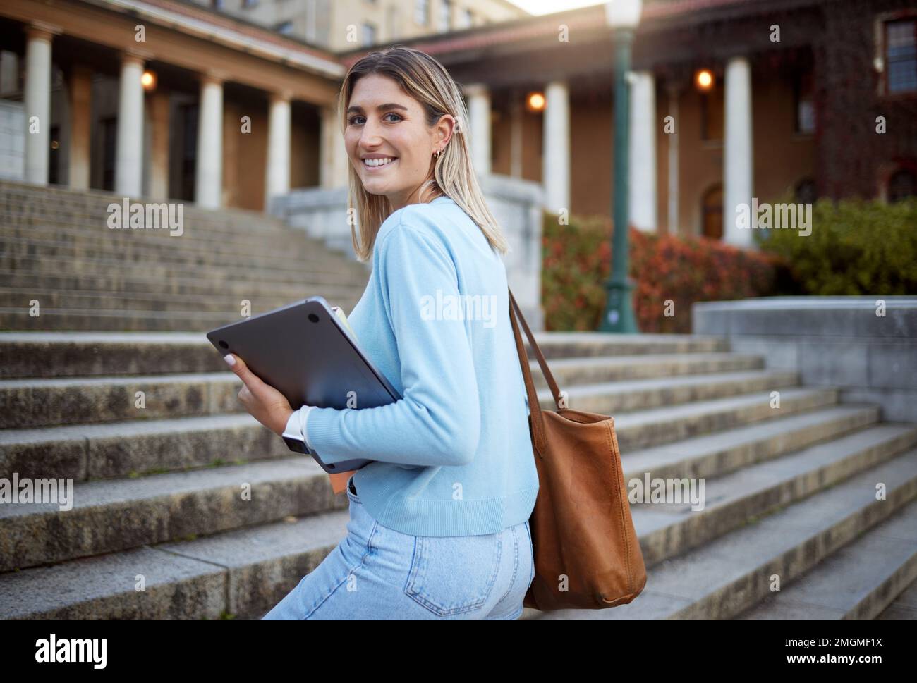 Woman, student portrait on university stairs and campus education with ...