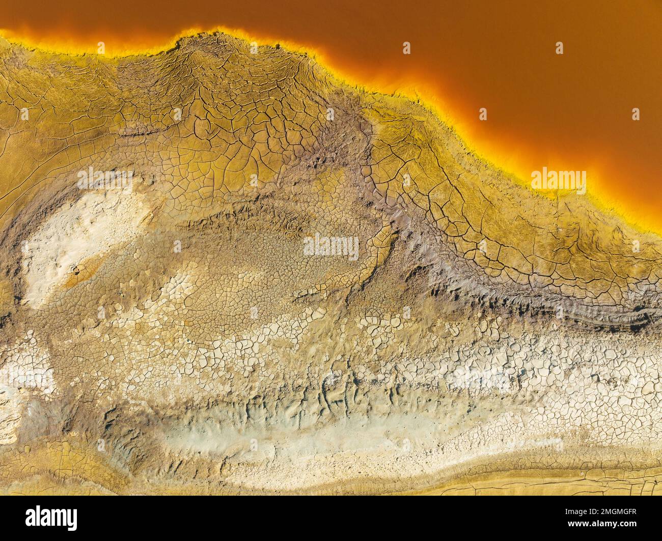 Cracked earth at the bank of the Rio Tinto (Red river) with its deep ...