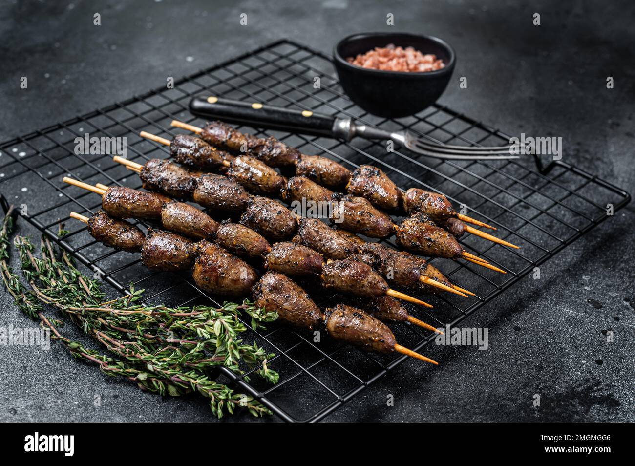 Grilled shish kebab with chicken hearts on a grill. Black background ...