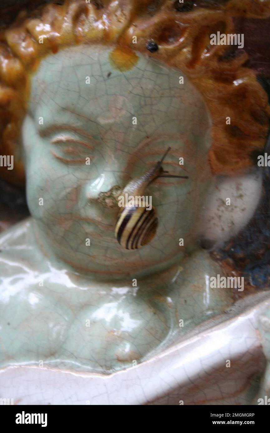 Deal of a slug on a ceramic angel figurine Stock Photo - Alamy