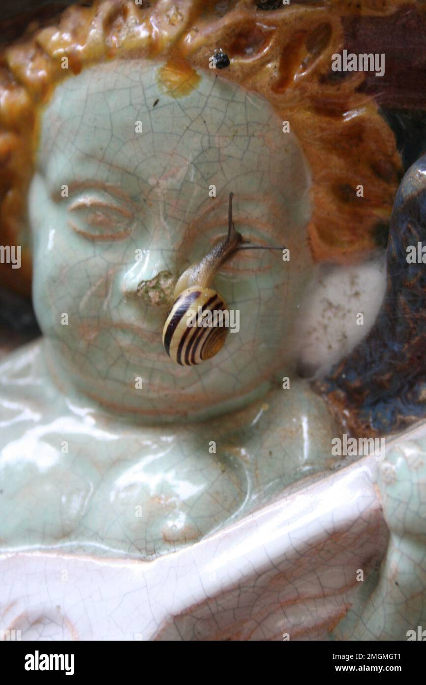 Deal of a slug on a ceramic angel figurine Stock Photo - Alamy