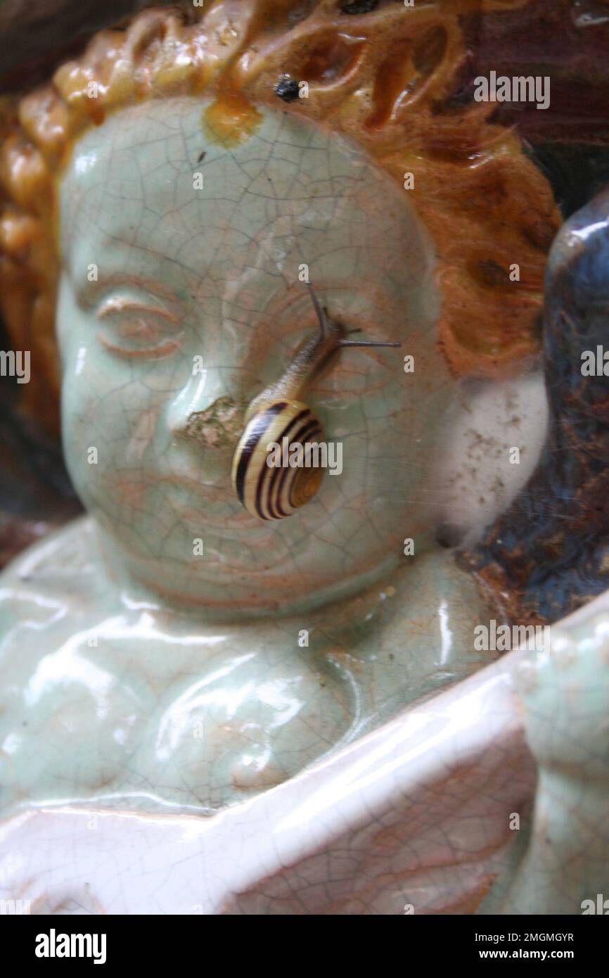 Deal of a slug on a ceramic angel figurine Stock Photo - Alamy