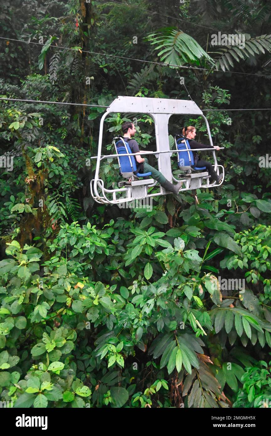 Clients of the lodge doing the aerian bike upon the forest. Mashpi ...