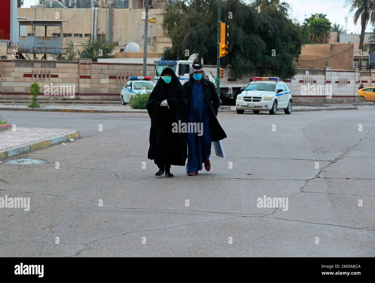 Iraqis walk in an empty street in central Baghdad, Iraq, Sunday, March ...